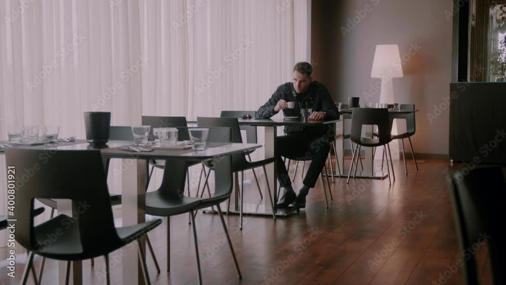 Man sitting alone in a restaurant and drinking out of a cup Stock Video ...