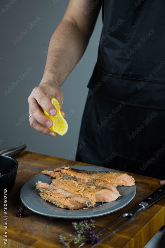 Chief cook squeezes lemon on carved fish baked in salt crust. Seafood ...