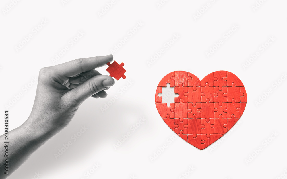 Heart-shaped puzzle and human hand with the missing piece of puzzle ...