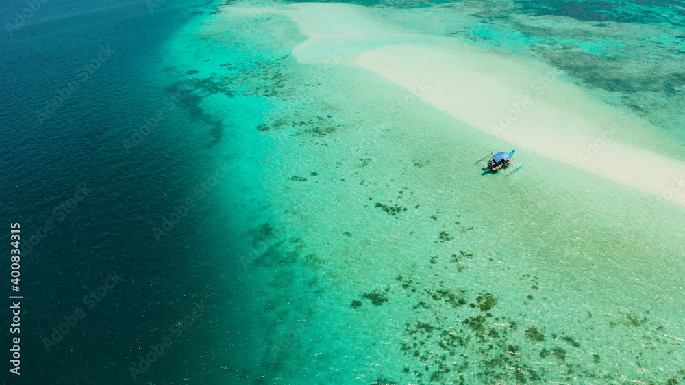 Sandy beach with tourists among turquoise waters and coral reefs ...