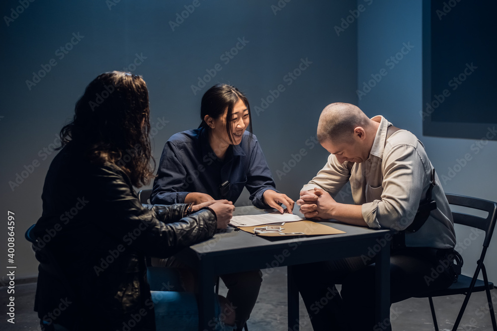 The murder suspect is in the interrogation room with a grim investigator and lawyer Stock Photo ...