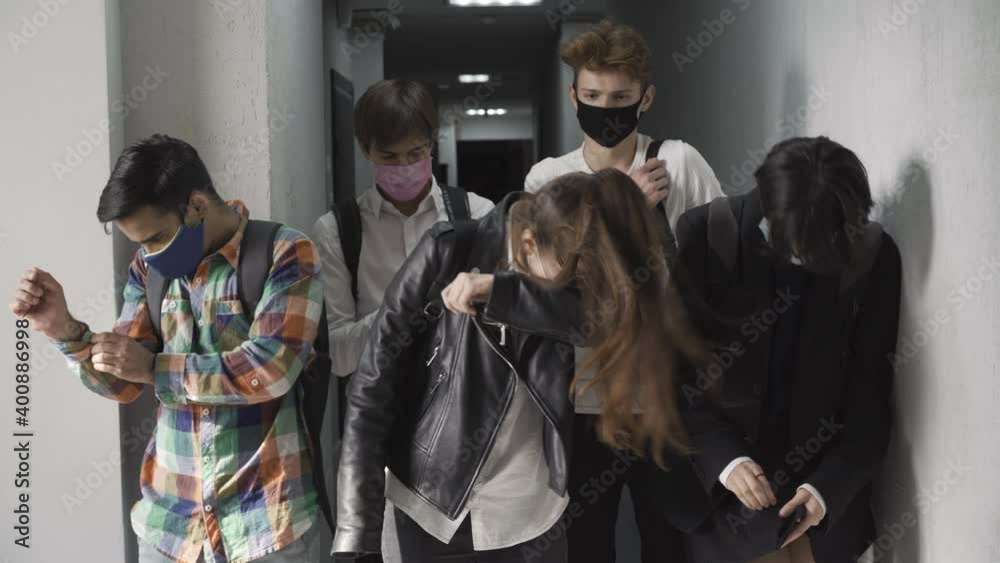 Girl in Covid-19 face mask sneezing and classmates leaving. Portrait of ...