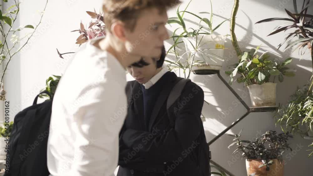 Portrait of crying Caucasian teenage girl standing at flowers in high ...