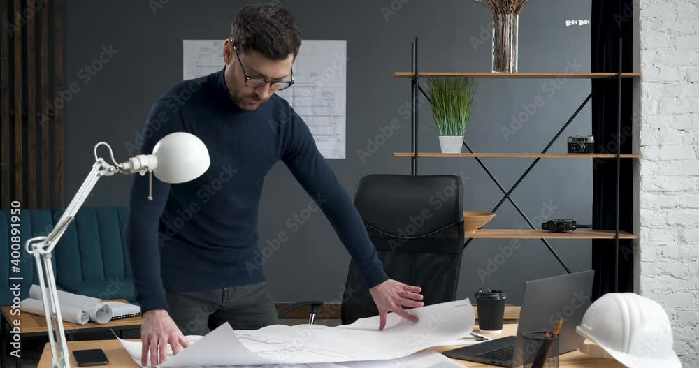 Frame of young concentrated Architect Works with Blueprints, Sketches ...