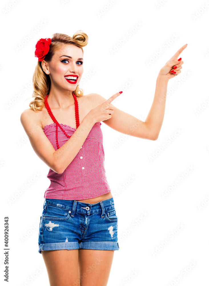 Amazed smiling woman pointing at something. Excited girl in pin up ...