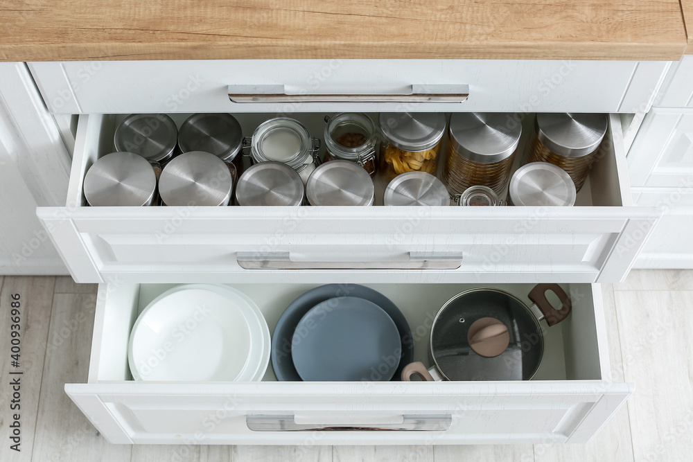 Glass jars with products and utensils in kitchen drawer Stock Photo ...