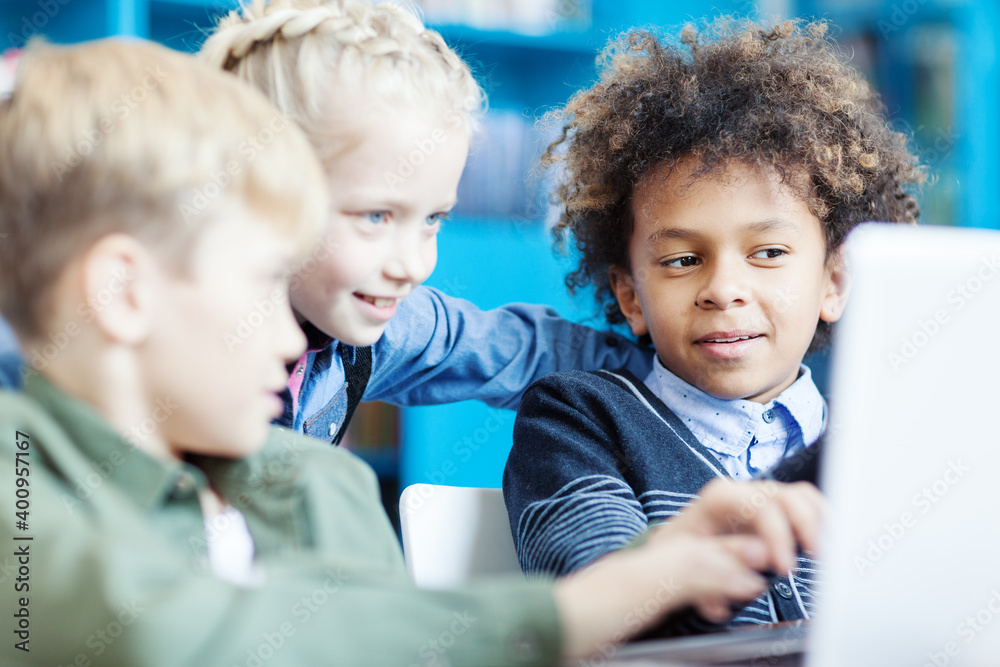 Side view of three curious little school students, two boys and girl ...