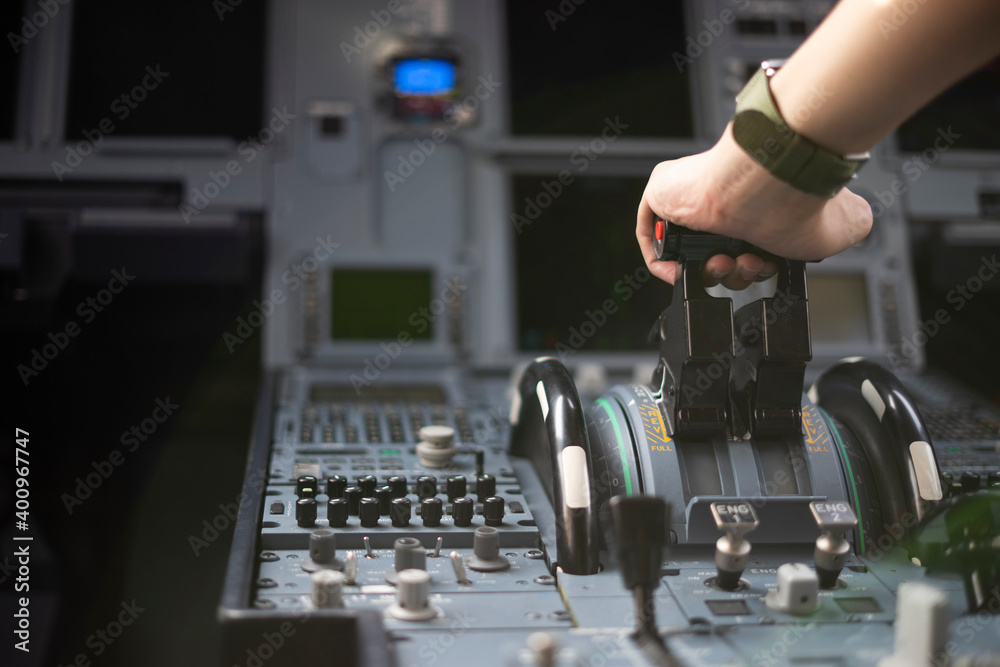 Cropped hands of pilot flying a commercial airplane, cockpit view close ...