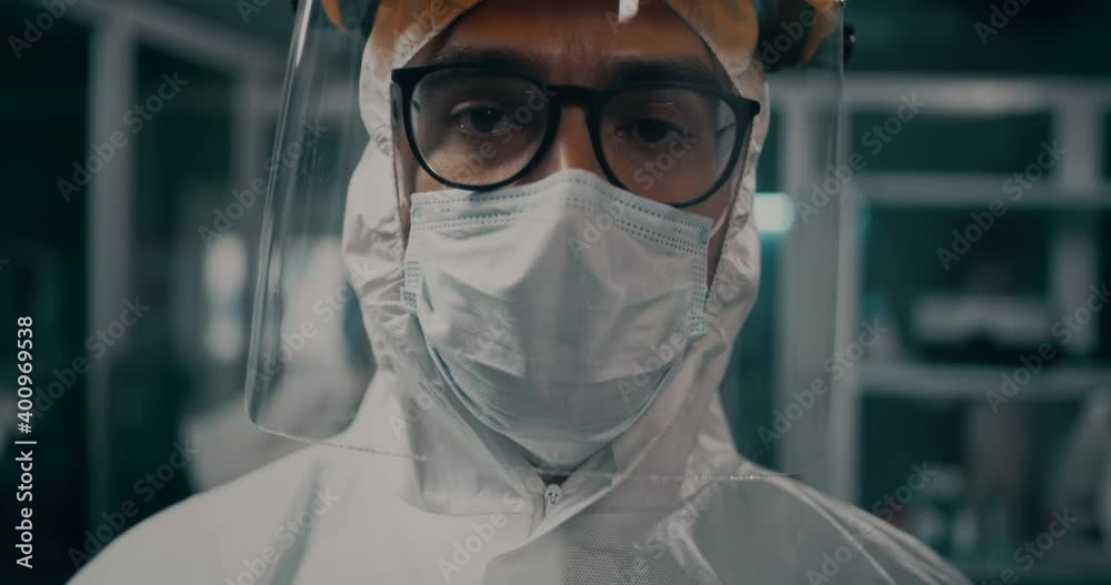 Doctor putting on face shield in lab Stock Video | Adobe Stock