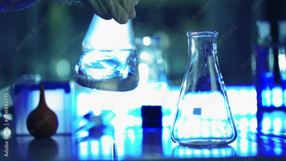 Scientist in laboratory doing chemical experiment with liquid in tube ...