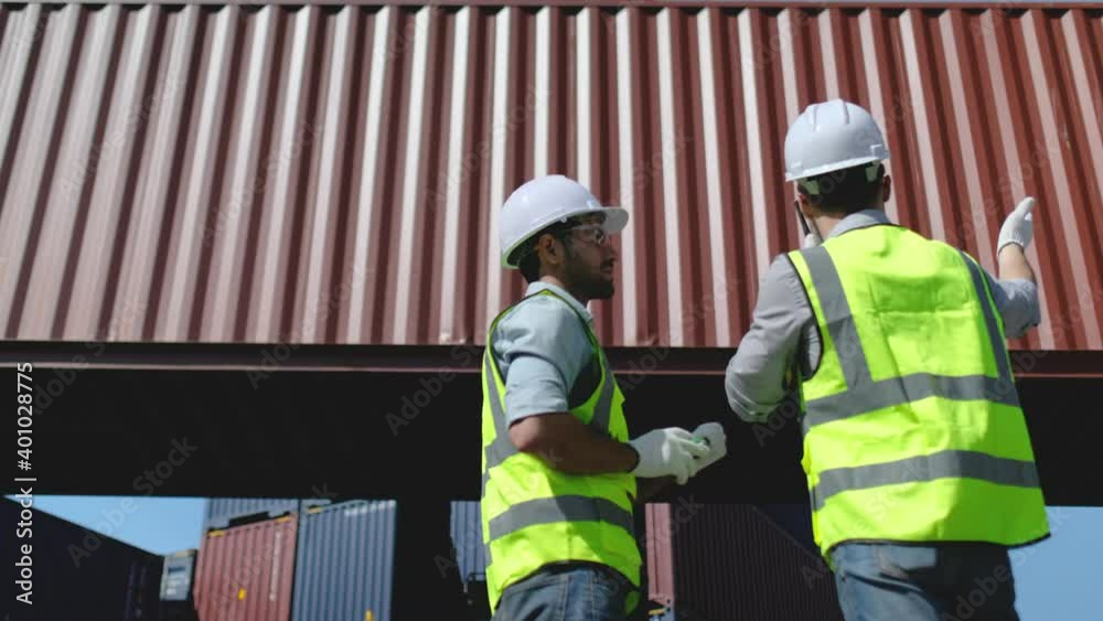 Two cargo container workers or engineer men work together during lift ...