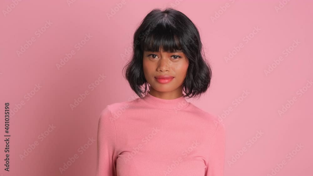 Disappointed sad asian woman has melancholic look at camera purses lips ...