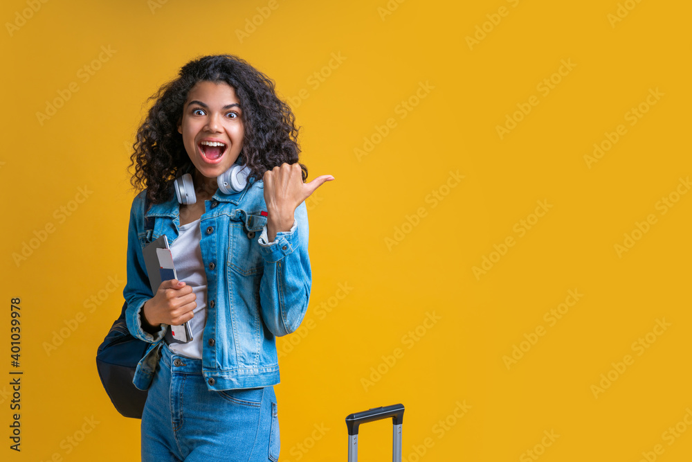 Excited dark skinned female tourist isolated over bright colored yellow ...
