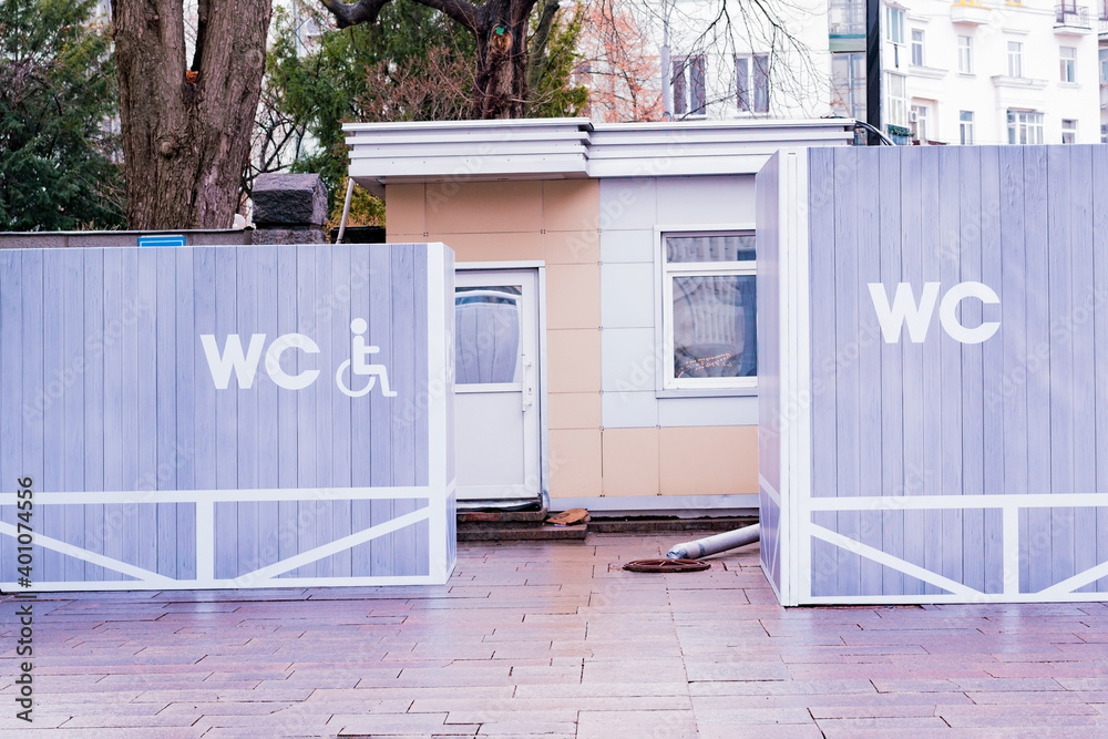 WC sign for disabled and common persons on drawn on the grey wooden ...
