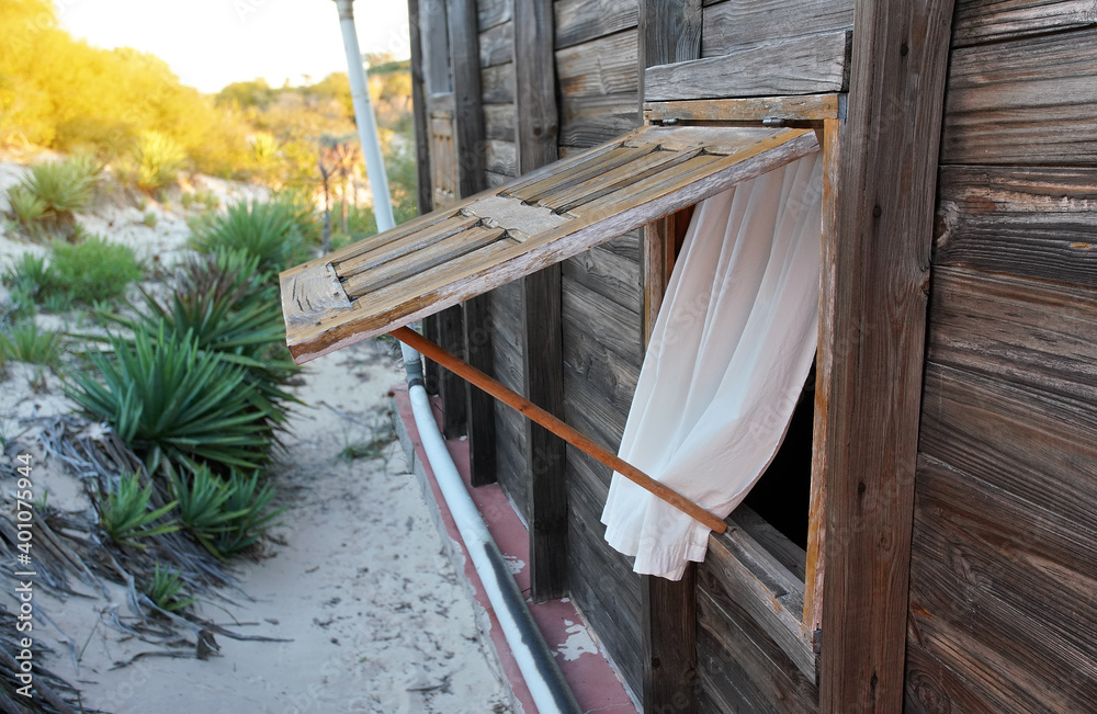 Beach house, wooden windows opened, sandy path leading to sea in ...