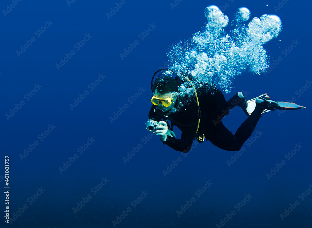 Recreational scuba diver with yellow mask, cloud of bubbles in black ...