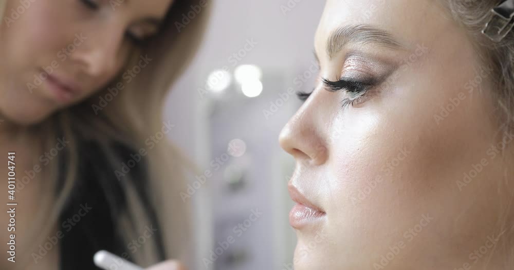 Professional makeup artist is applying blush bronzer using brush to ...