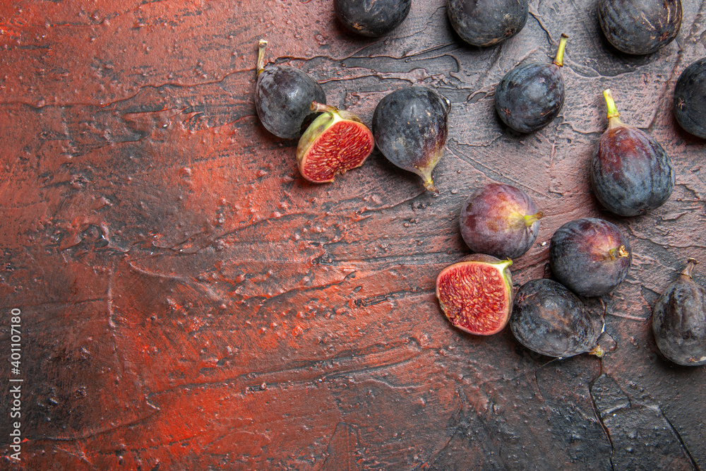 Horizontal view of full fresh black mission figs split ones on colorful ...