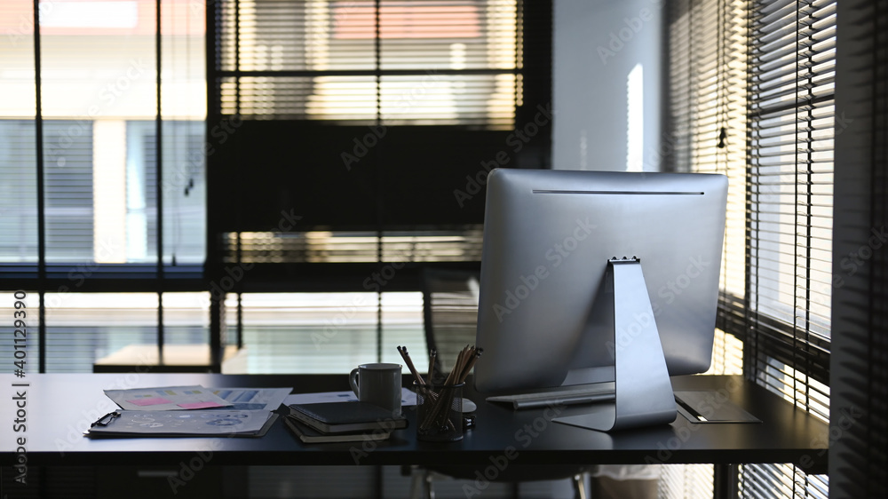 Foto de Rear view of office desk with computer, business documents and ...
