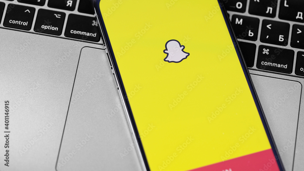 Snapchat logo on the screen iPhone, notebook closeup. Snapchat is a ...