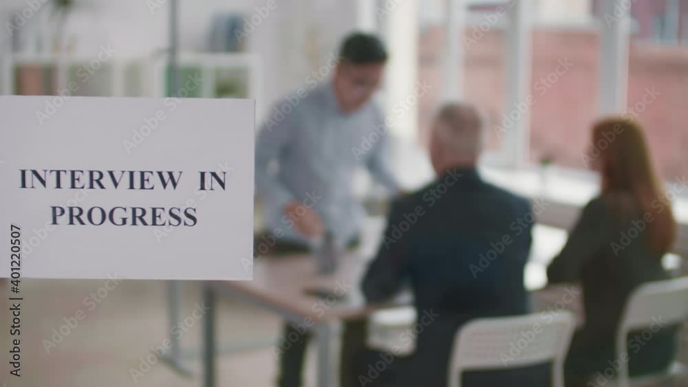 Interview in progress sign printed on paper hanging on glass wall in ...