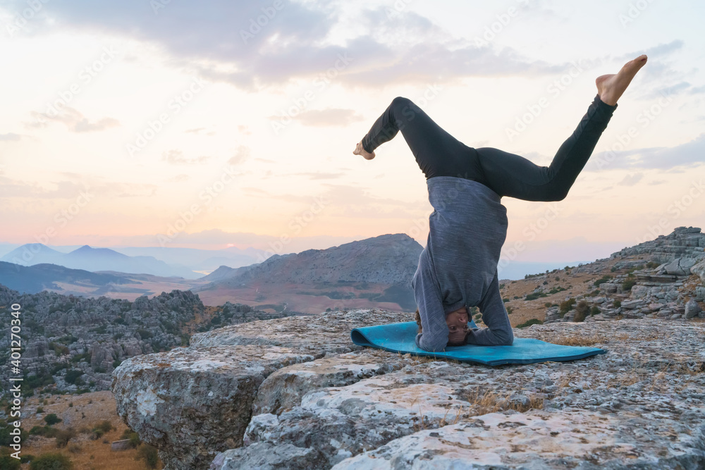 Full body of barefoot female standing in yoga pose on top of mountain ...