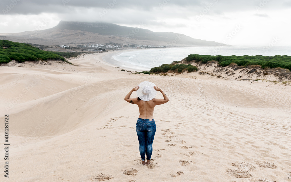 Back view full length shirtless woman wearing denim jeans and hats ...