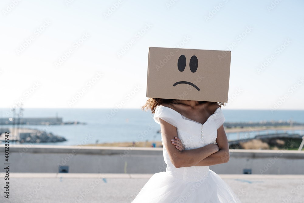 Foto de Unrecognizable woman wearing white bridal dress and carton box ...