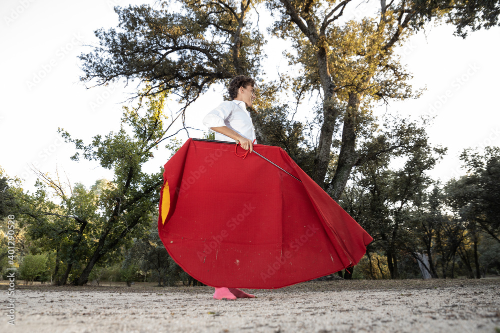 From below side view of happy slim male bullfighter in red pants and ...