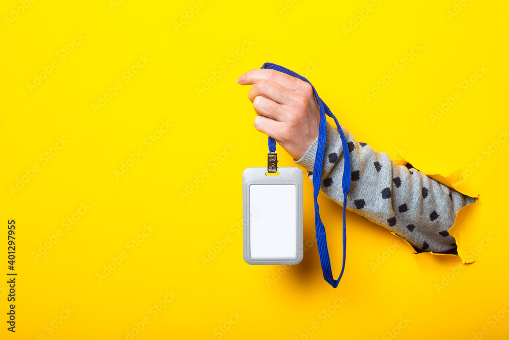 Woman's hand holds a blank name tag on a torn yellow background Stock ...