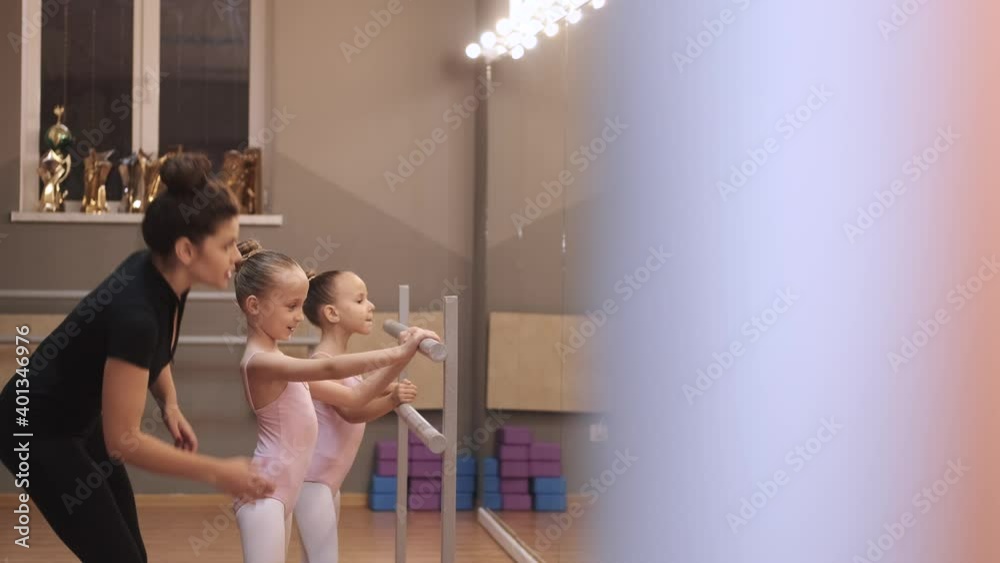 Ballet teacher teaching young dancers. Female ballet teacher helping ...