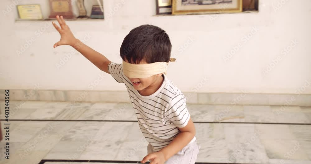 Slow-motion portrait of a young male child blindfolded as he walks ...