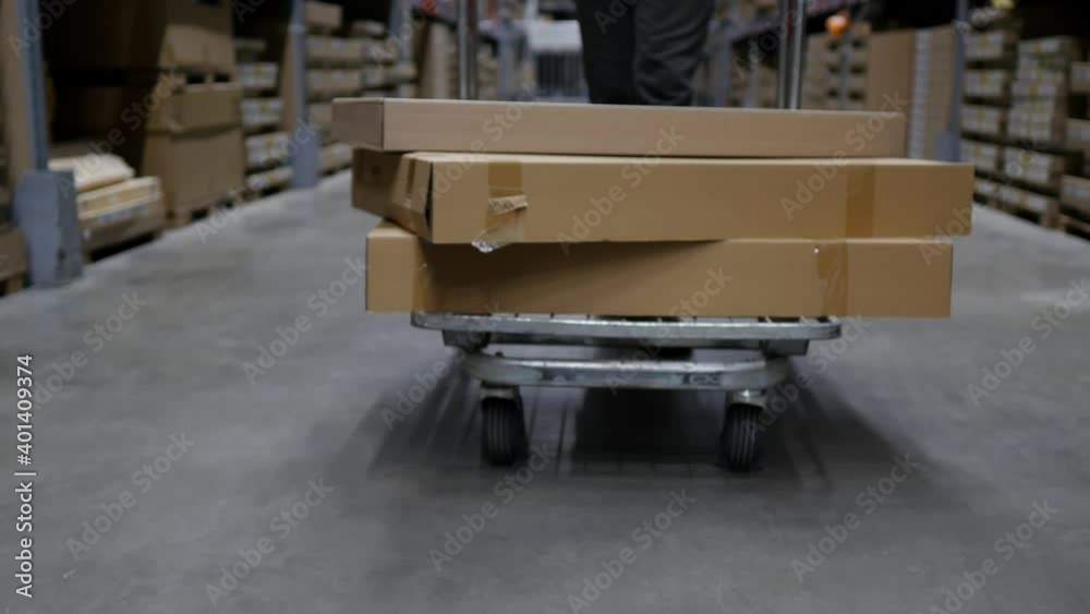 A shopper makes purchases on shelves in a large warehouse retail store ...