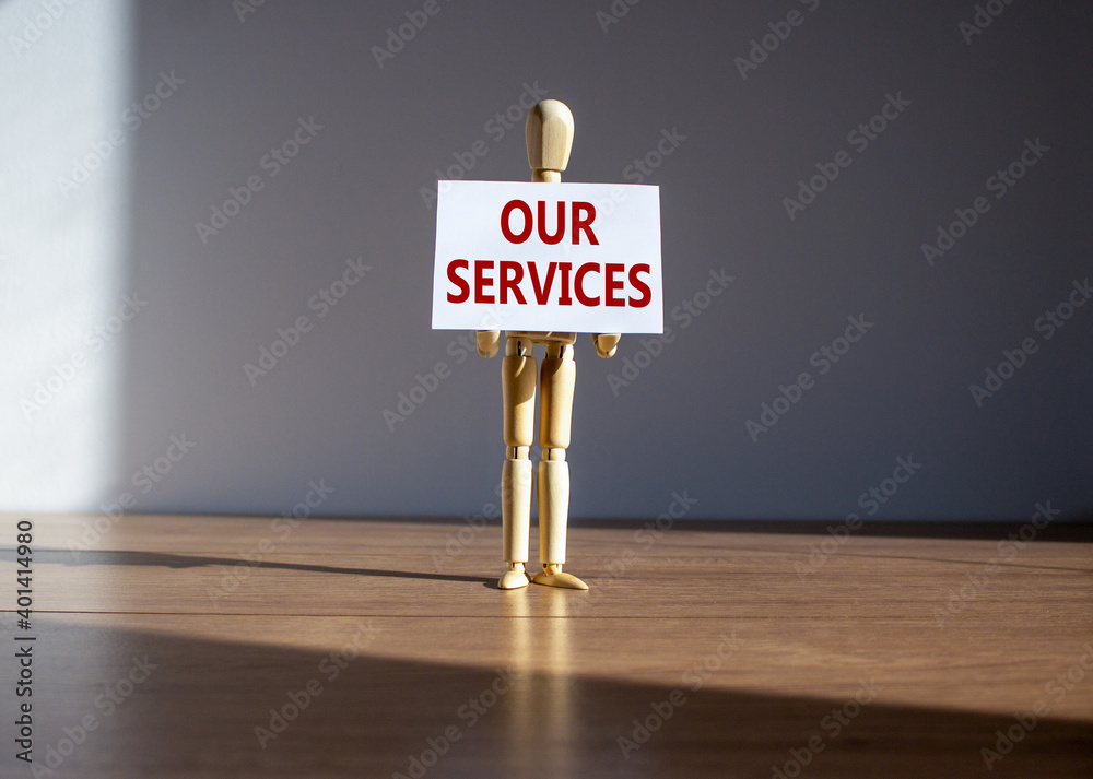Our services symbol. Wooden model of human holding a white paper with ...