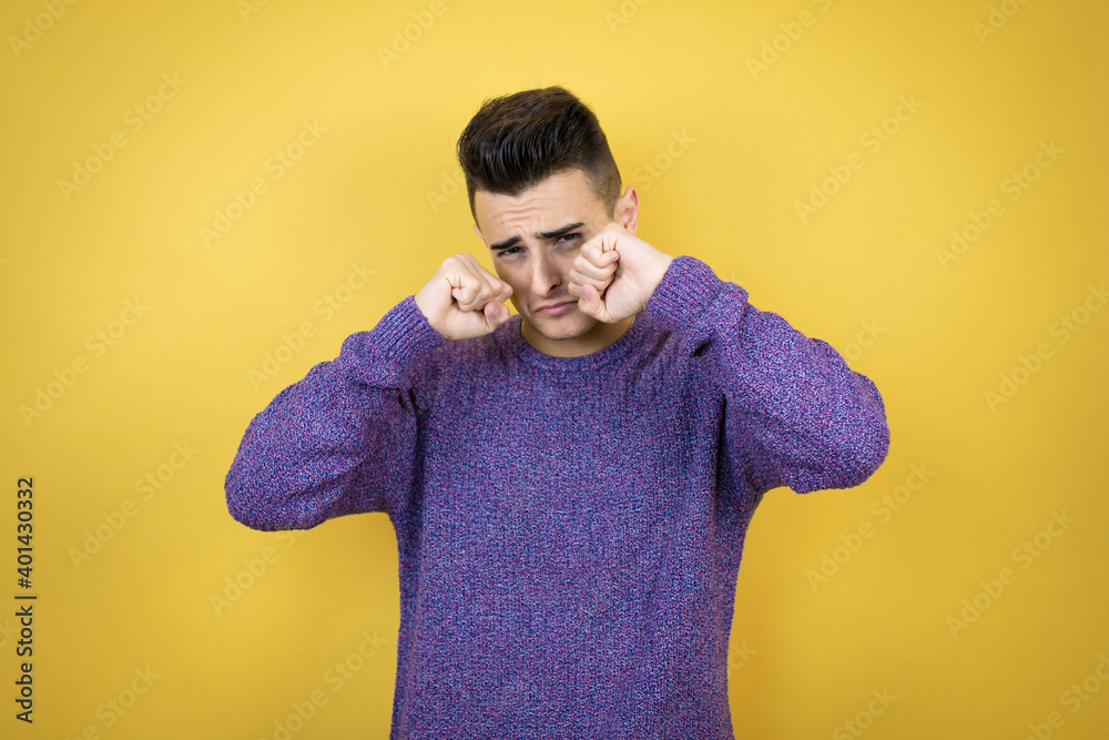 Young caucasian man over isolated yellow background depressed and worry ...