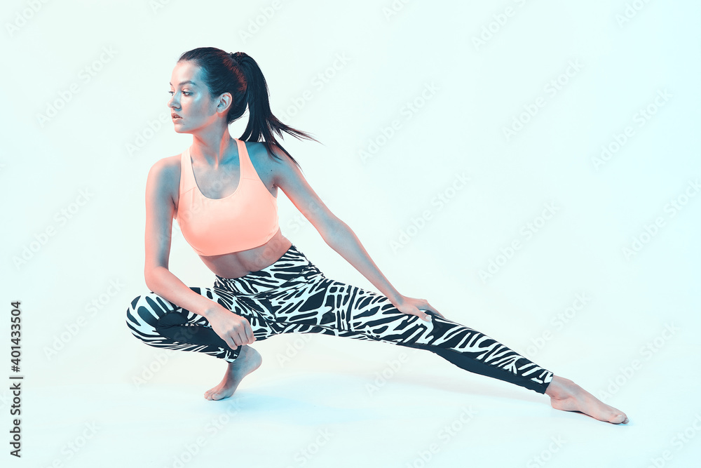 Sporty girl posing in sport clothes in neon light. Fit young model with ...