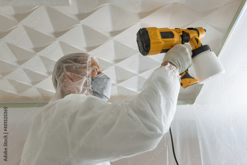 The painter is painting a 3d ceiling with a spray gun. foto de Stock ...