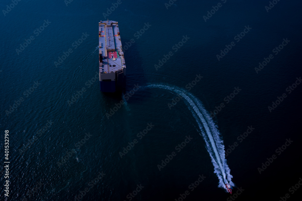 Large RoRo carrier vessel and tug boat sailing on the sea dramatic at ...