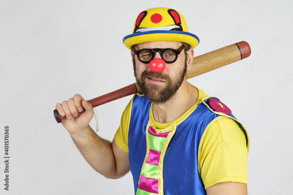 The clown is a man in a bright blue and yellow suit with a baseball bat ...