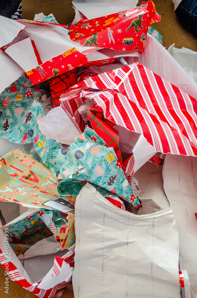 Discarded Christmas wrapping paper thrown in a big pile on the floor ...