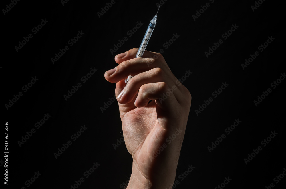 Hand with injection syringe on black background Stock Photo | Adobe Stock