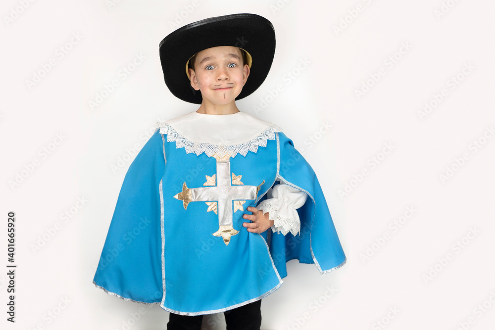 A young boy in a carnival blue musketeer costume and a black hat on a ...