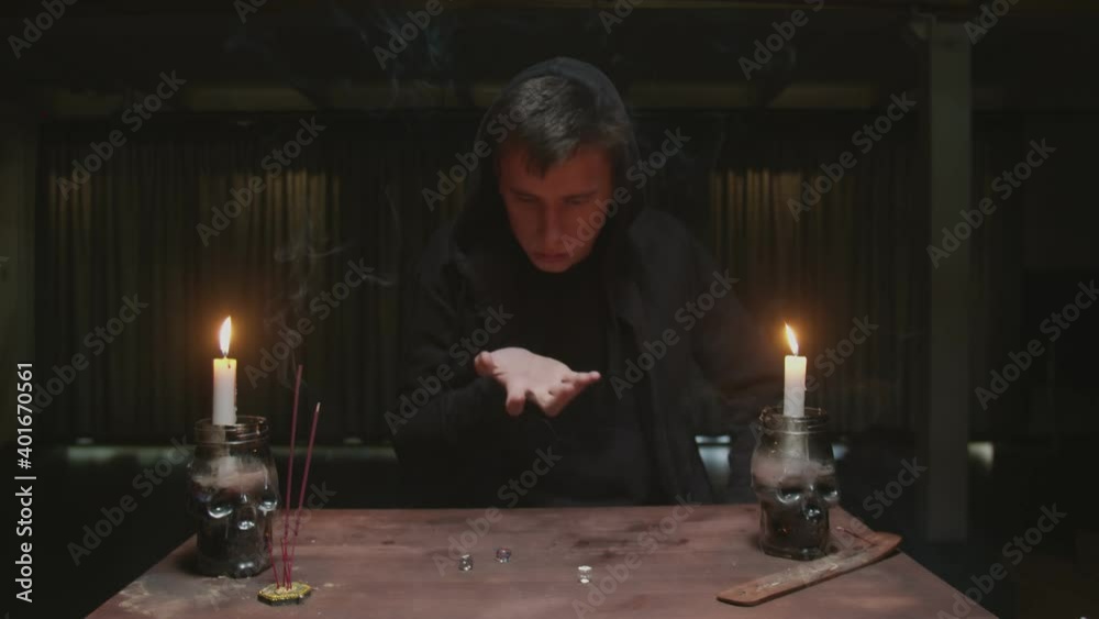 Concentrated mysterious wizard male fortune teller uses dices to magic ...