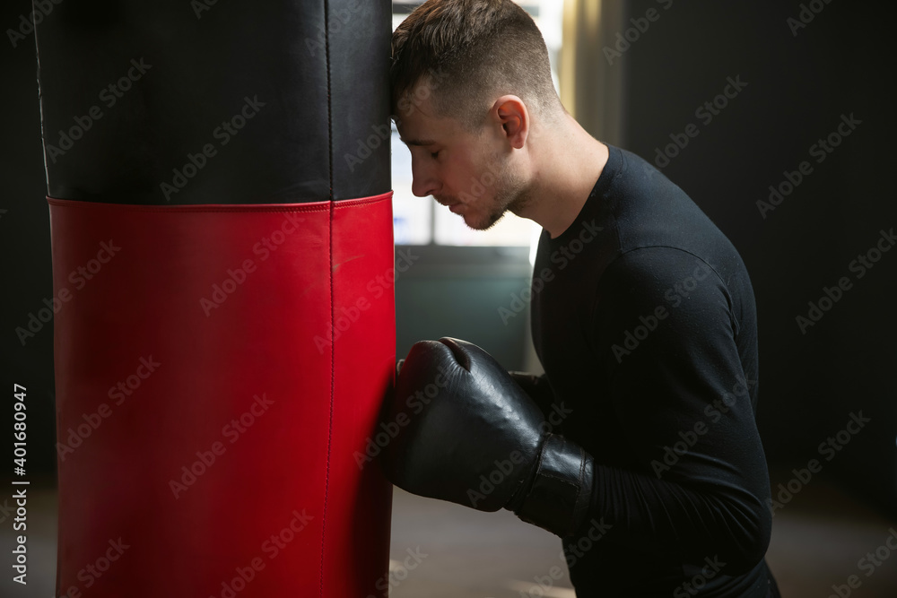 Tired boxer after training. A boxer stands by a punching bag. Workout ...