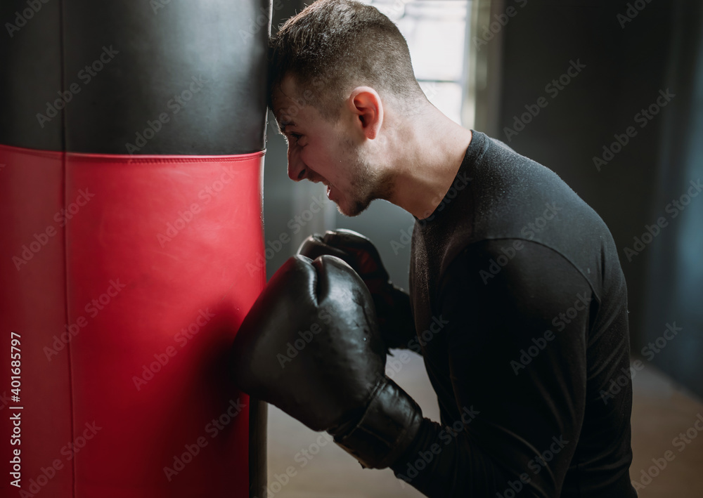 Tired boxer after training. A boxer stands by a punching bag. Workout ...