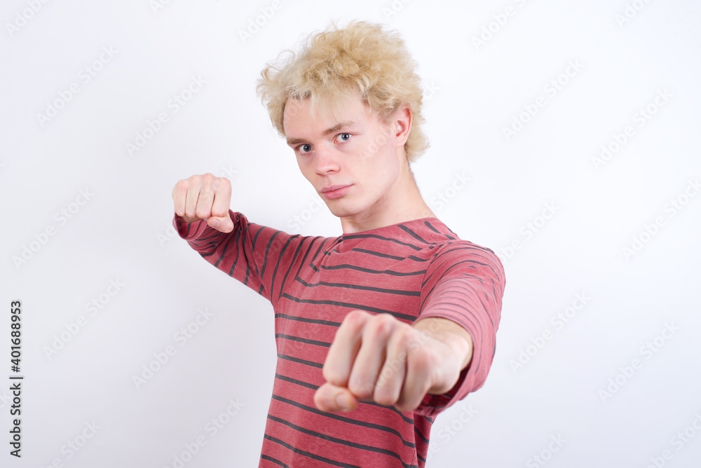 Young handsome Caucasian blond man standing against white background ...