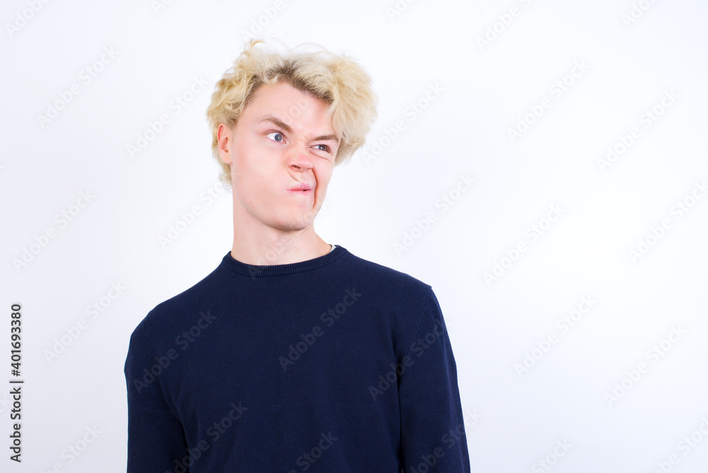 Young handsome Caucasian blond man standing against white background ...