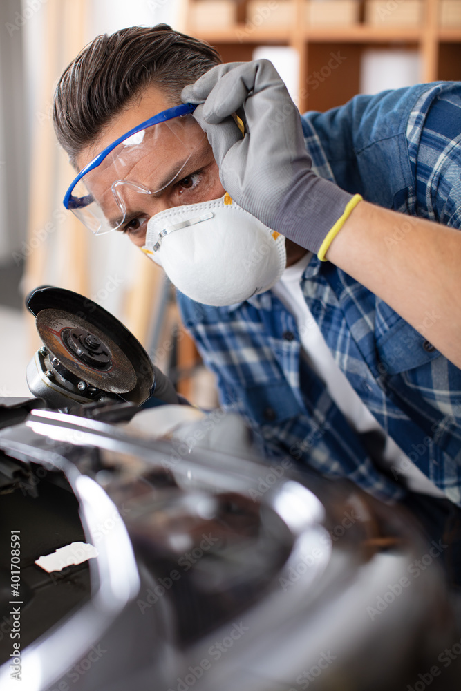 mechanic wearing dust mask using an angle grinder Stock Photo | Adobe Stock