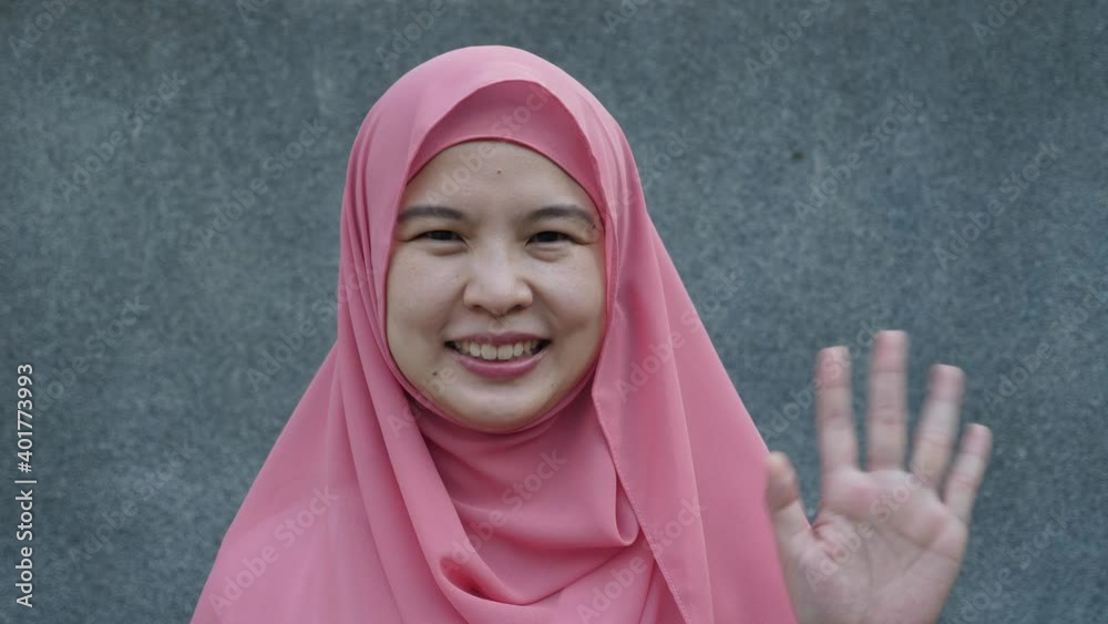 Cheerful and pretty young South East Asian Muslim woman in pink hijab ...