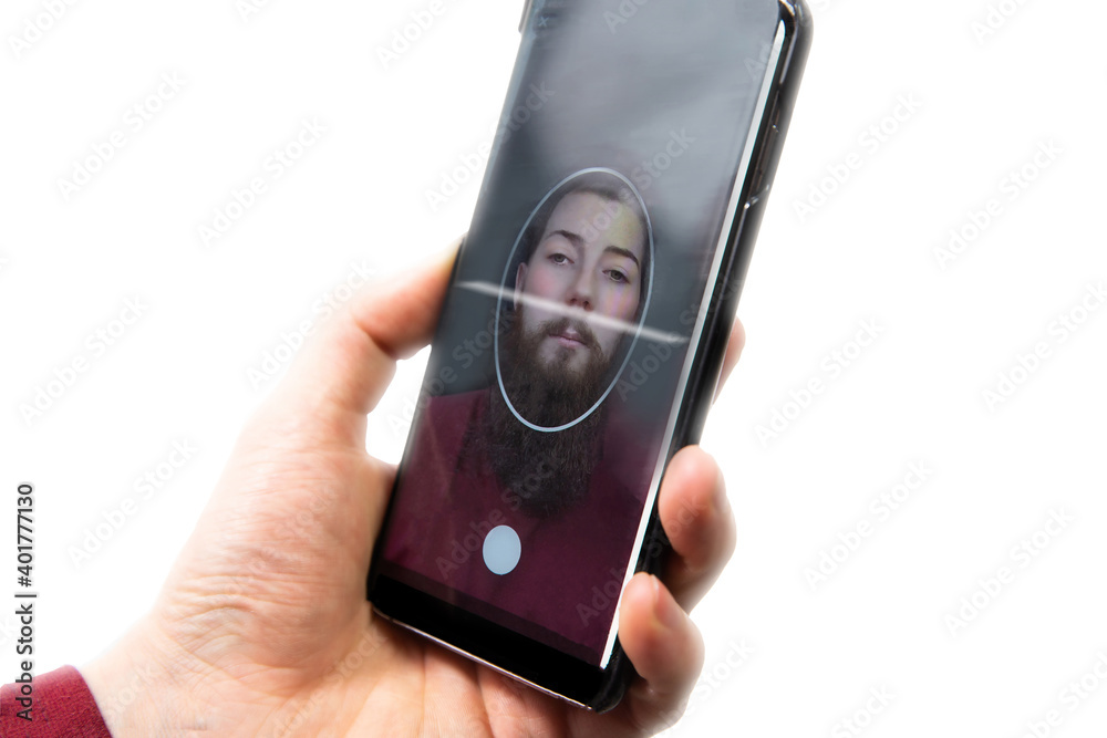 Young male holding mobile phone for scanning face, for changing face to ...